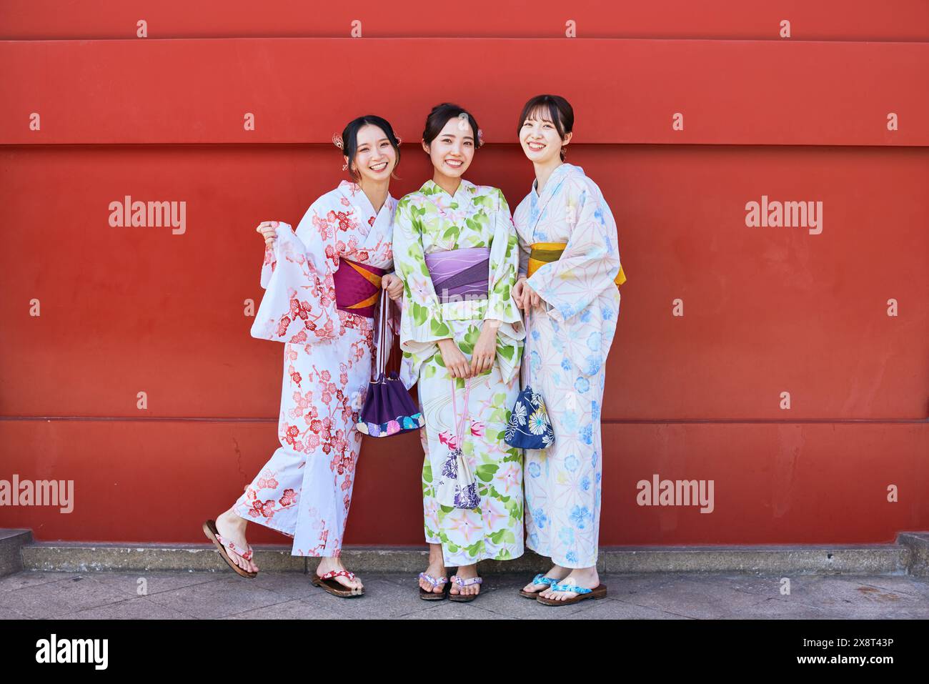 Japanese friends wearing yukata visiting traditional temple in Tokyo ...