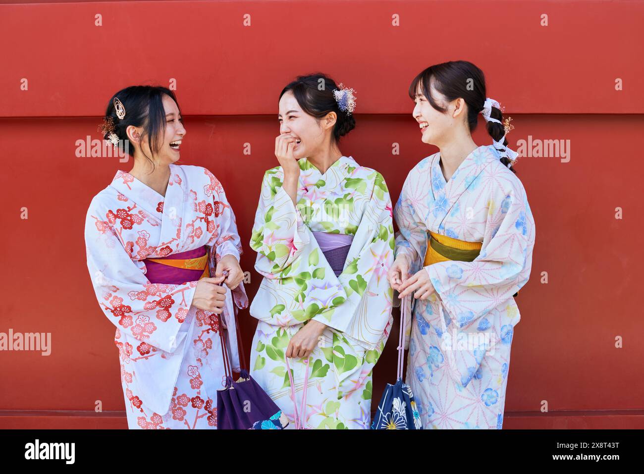 Japanese friends wearing yukata visiting traditional temple in Tokyo ...