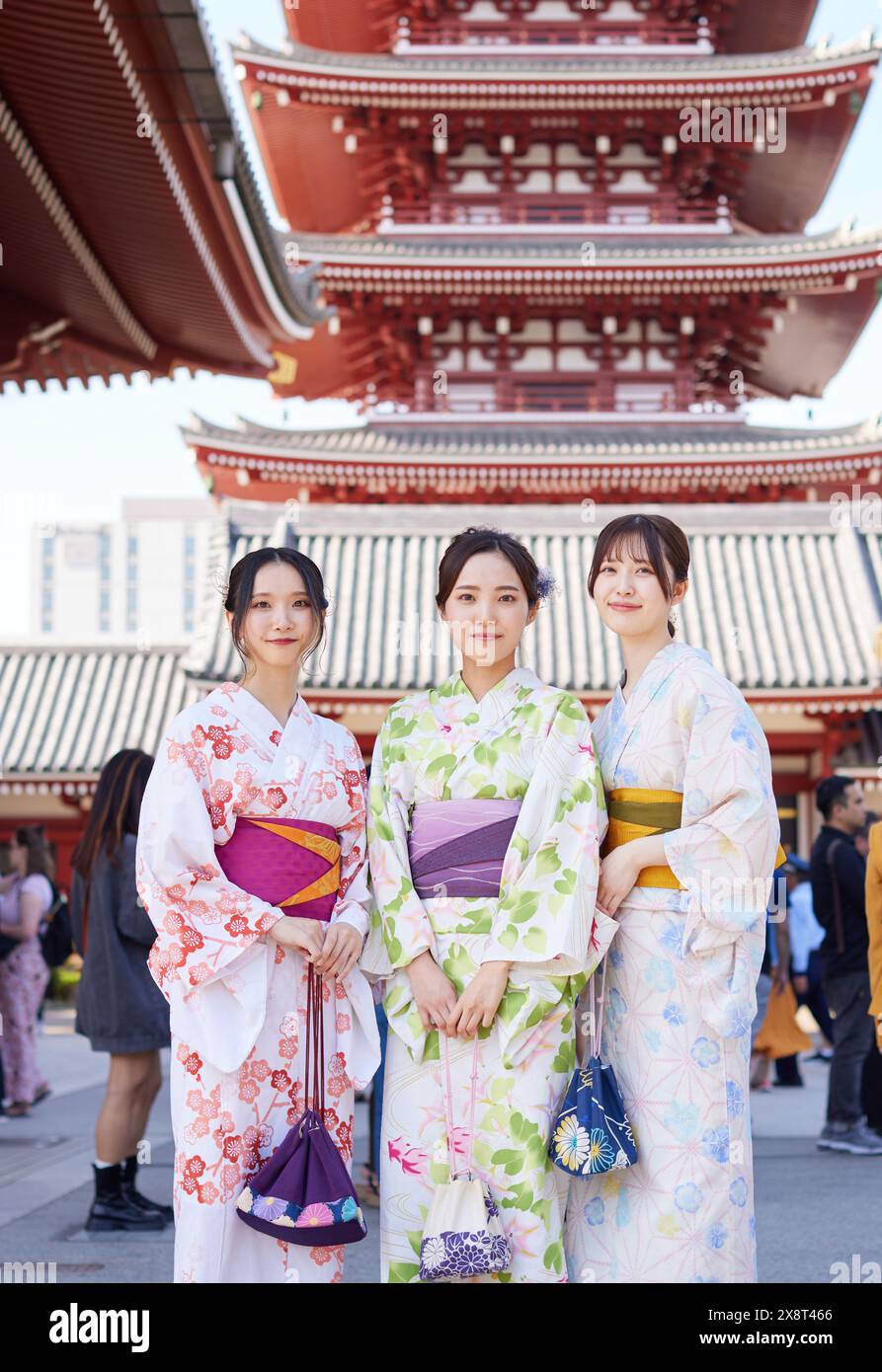 Japanese friends wearing yukata visiting traditional temple in Tokyo ...