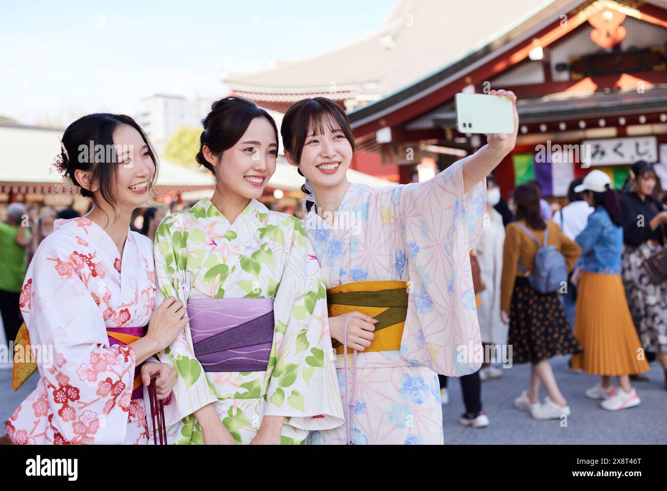 Japanese friends wearing yukata visiting traditional temple in Tokyo ...