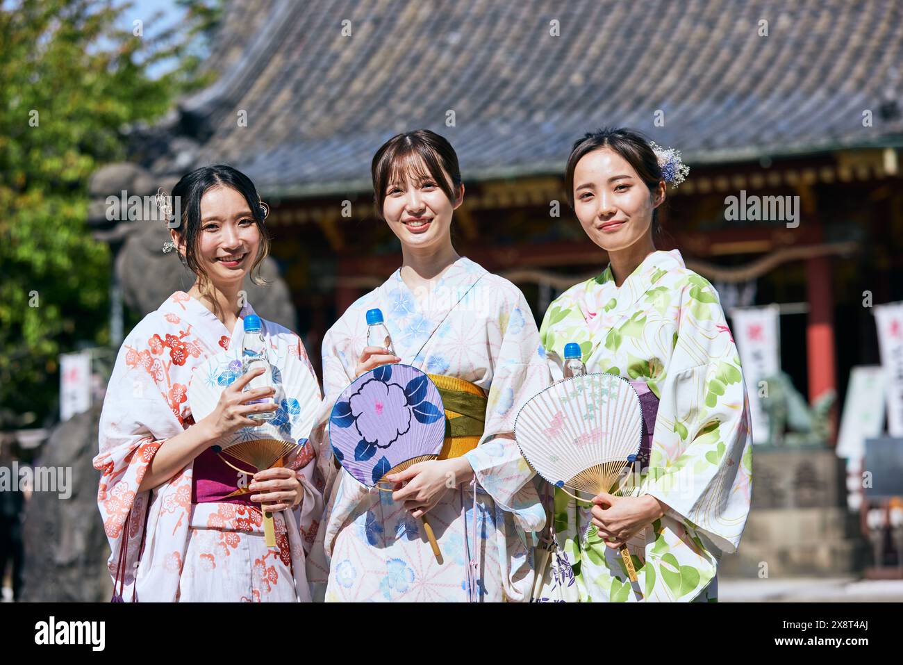Japanese friends wearing yukata visiting traditional temple in Tokyo ...