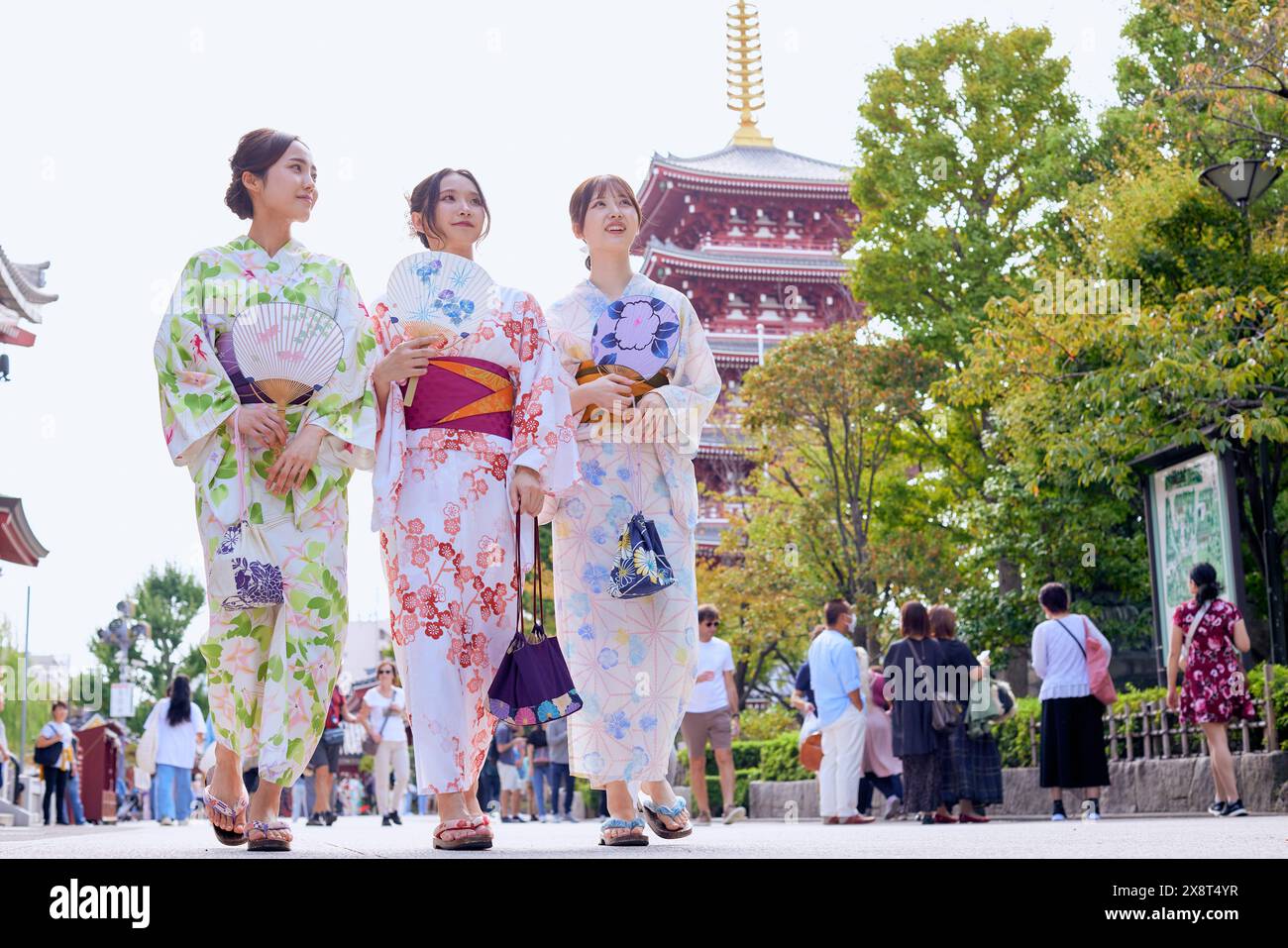 Japanese friends wearing yukata visiting traditional temple in Tokyo ...