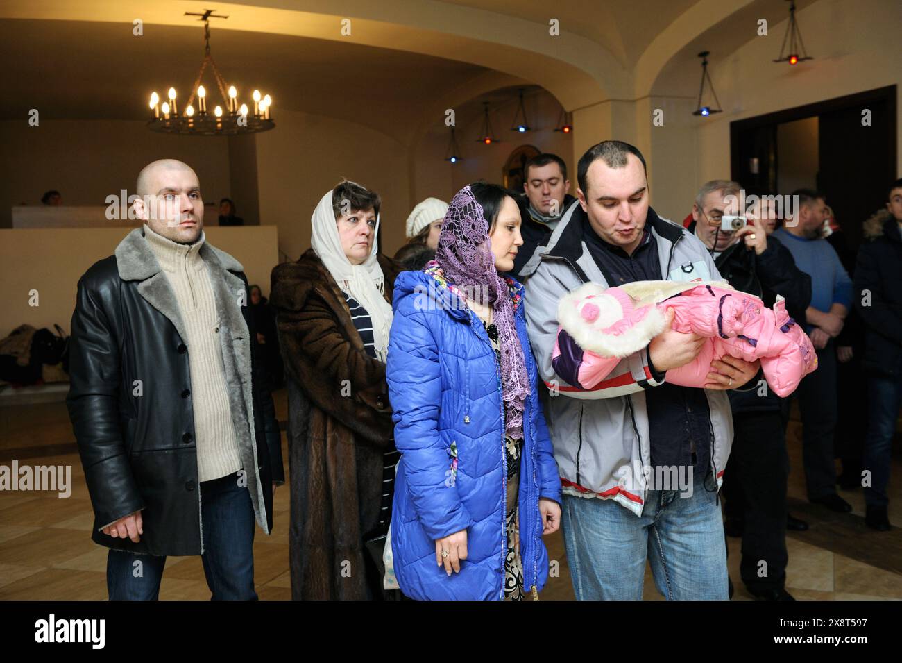 Christening for baby in rural church. Parents standing with baby on ...