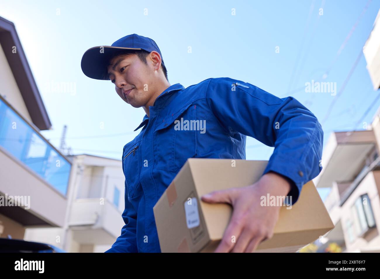 Japanese delivery man holding a box Stock Photo - Alamy