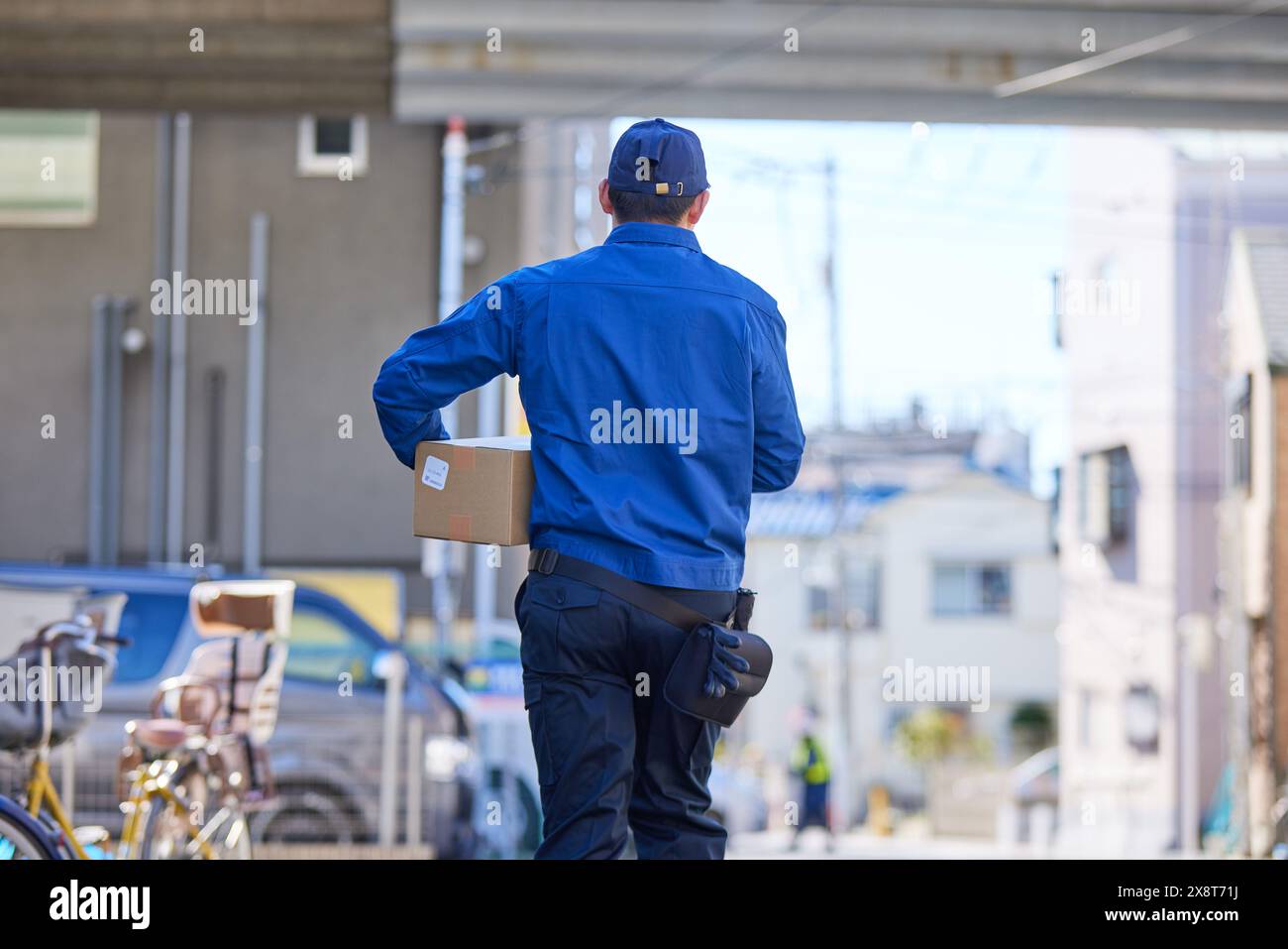 Japanese delivery man carrying a box Stock Photo - Alamy