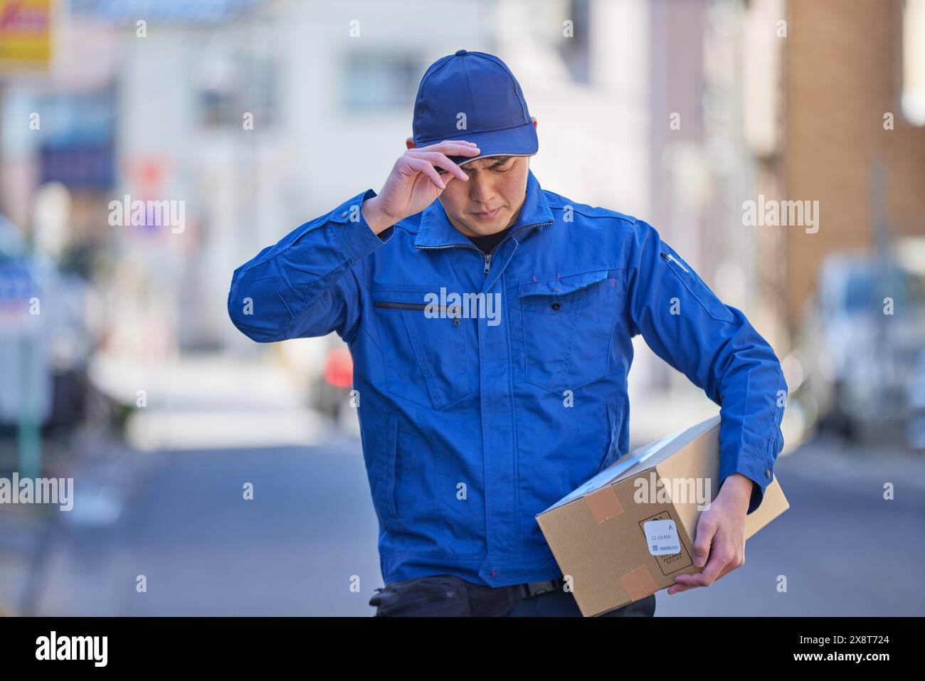 Japanese delivery man holding a package Stock Photo - Alamy