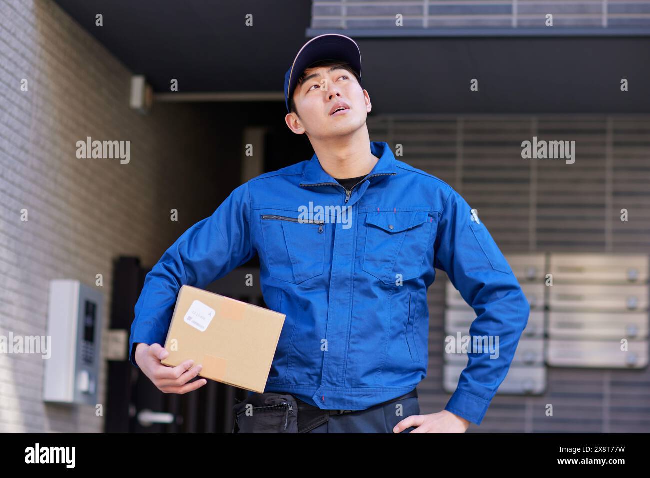 Japanese delivery man holding a package Stock Photo - Alamy