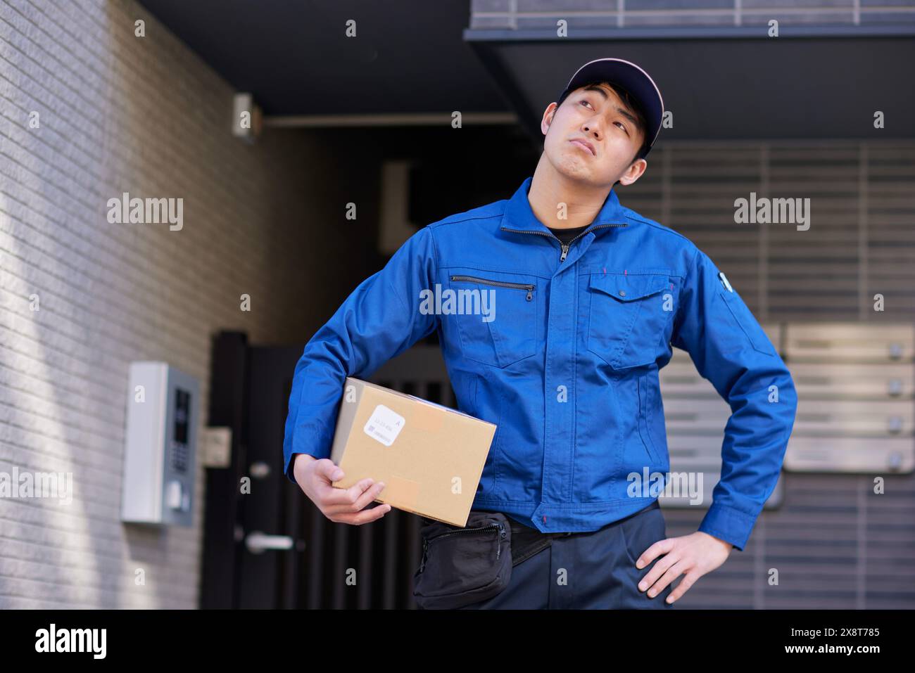 Japanese delivery man holding a package Stock Photo - Alamy