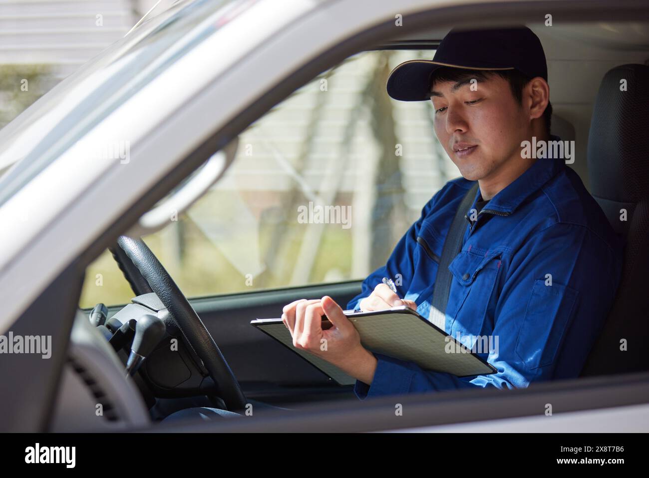 Japanese delivery man sitting in the driver seat of a car Stock Photo ...