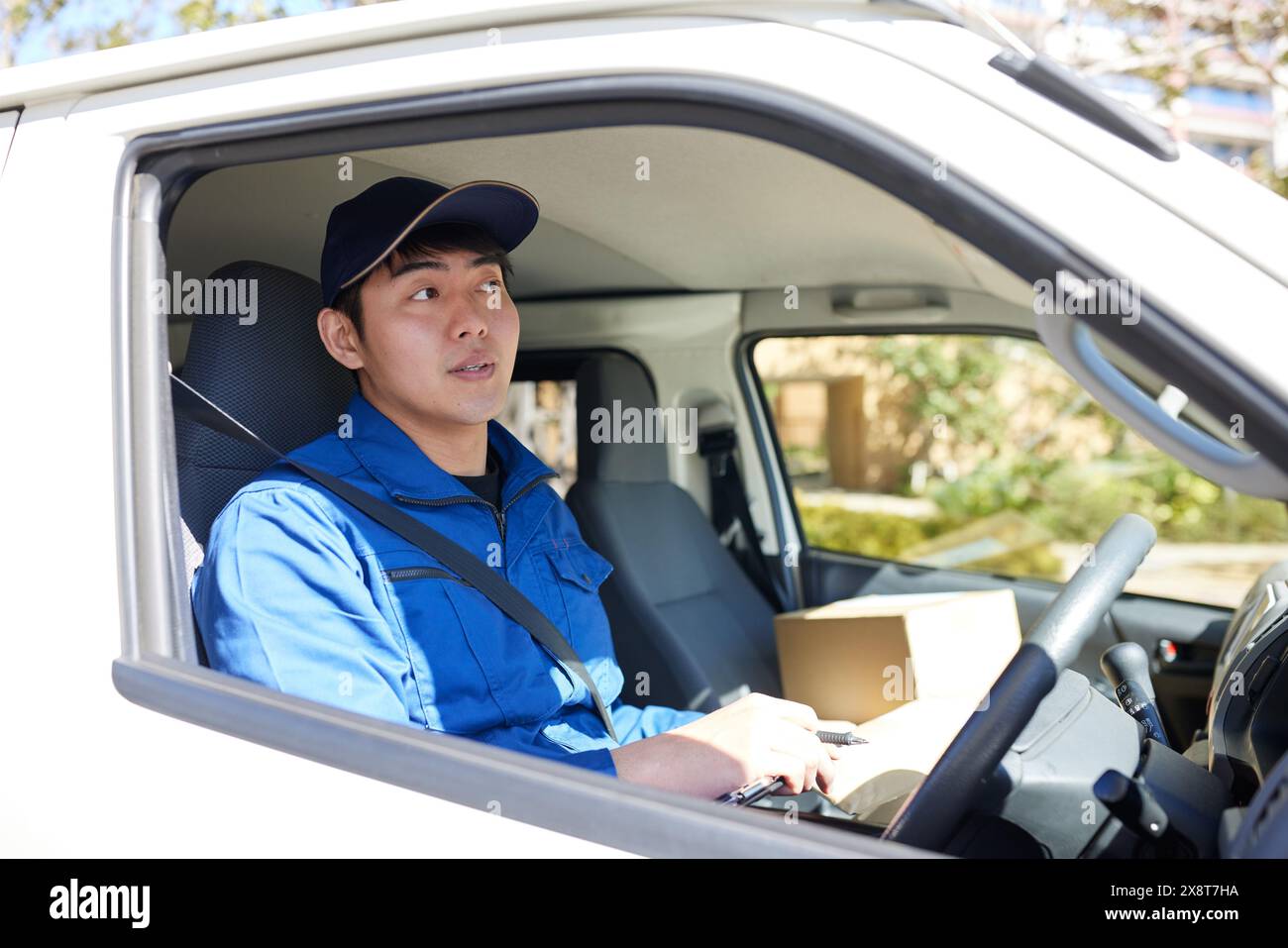 Japanese delivery man sitting in the driver seat Stock Photo - Alamy
