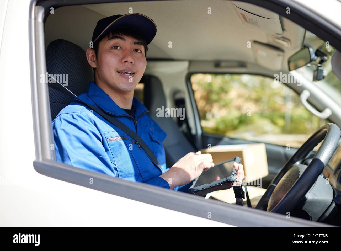 Japanese delivery man sitting in the driver seat Stock Photo - Alamy