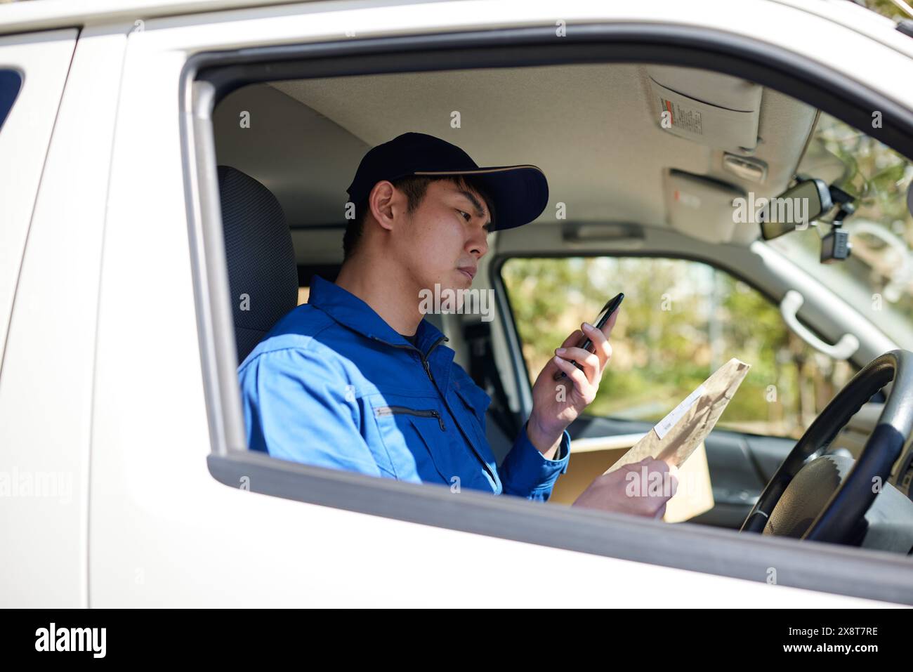 Japanese delivery man sitting in the driver seat Stock Photo - Alamy