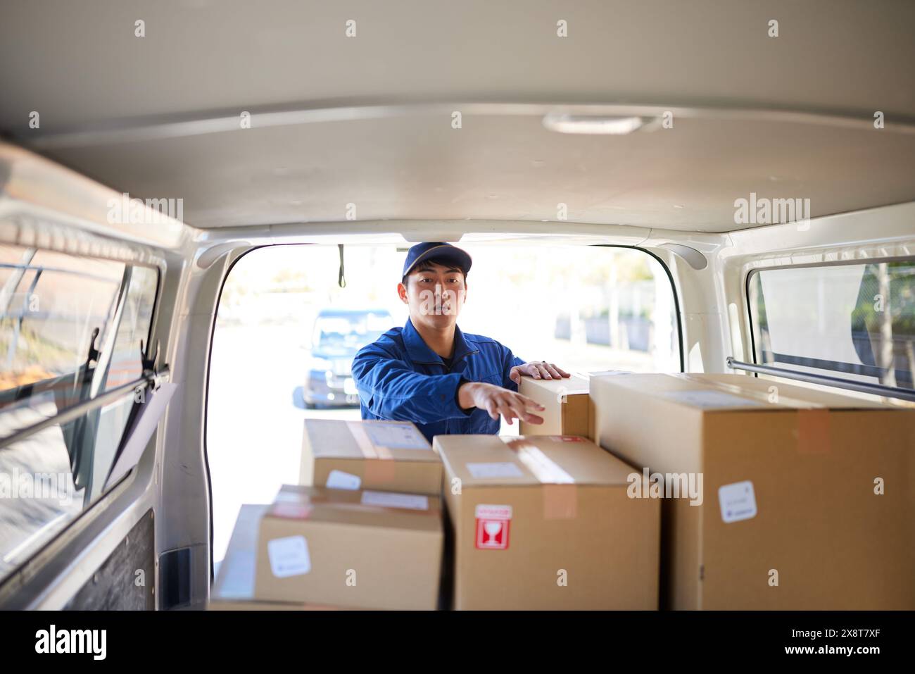 Japanese delivery man checking boxes in the car Stock Photo - Alamy