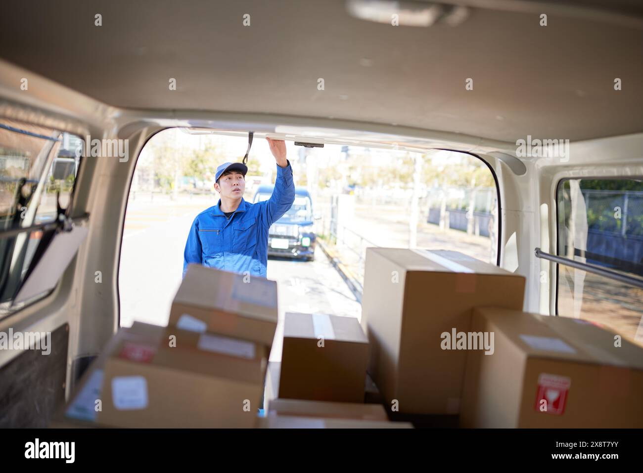Japanese delivery man checking boxes in the car Stock Photo - Alamy
