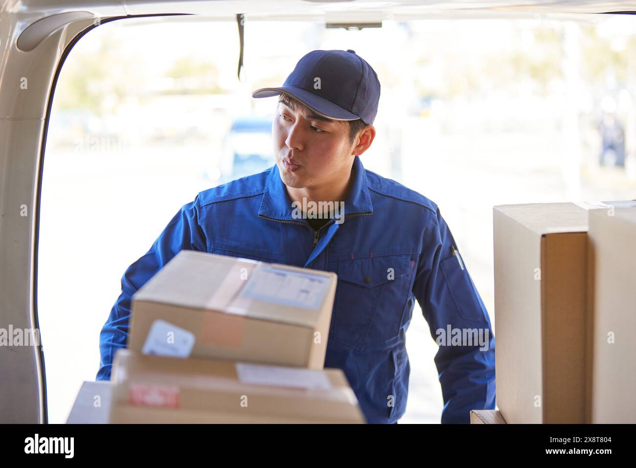 Japanese delivery man checking boxes in the car Stock Photo - Alamy
