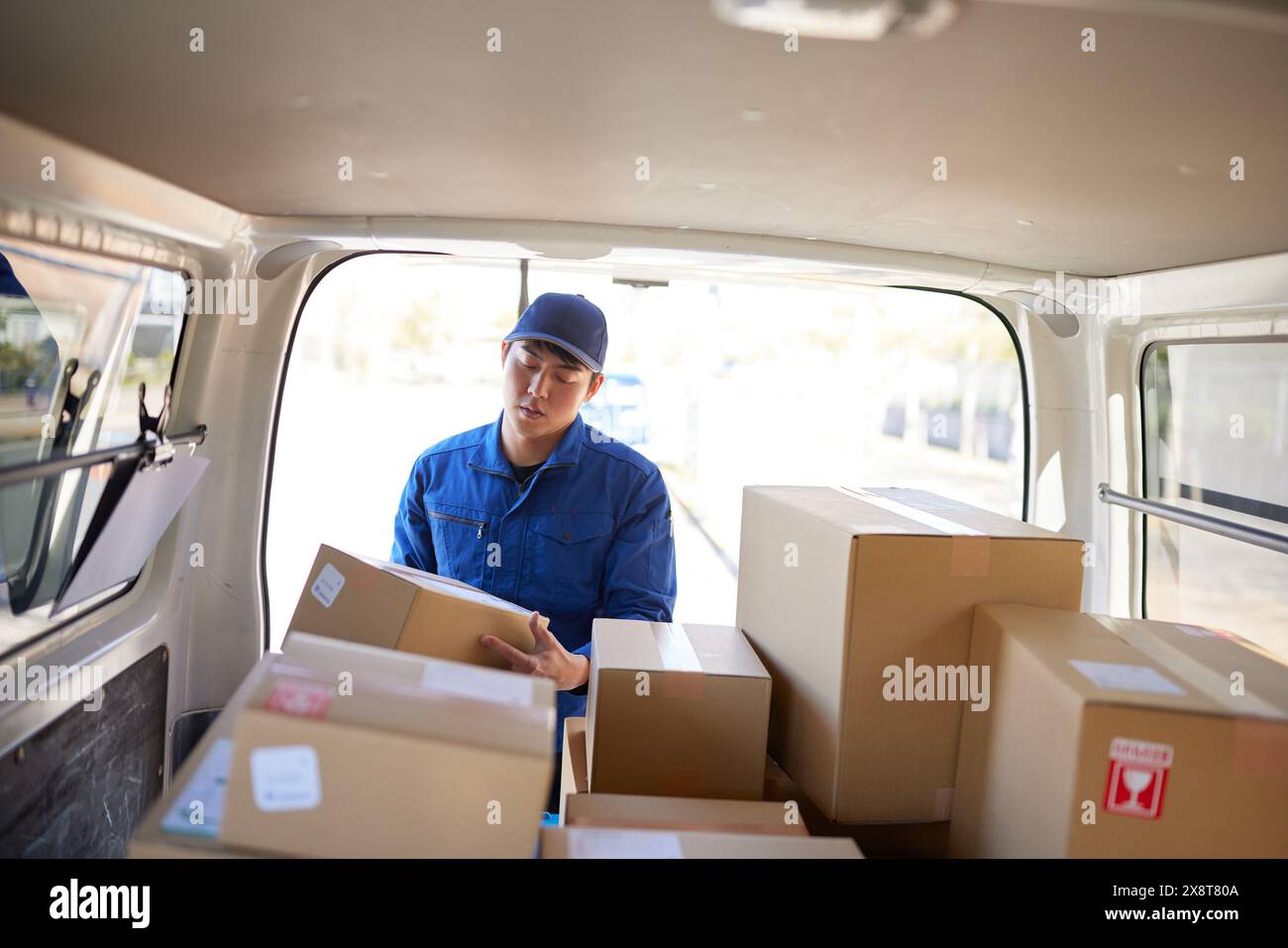 Japanese delivery man checking boxes in the car Stock Photo - Alamy
