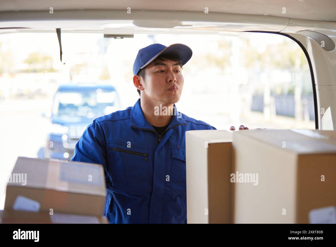 Japanese delivery man checking boxes in the car Stock Photo - Alamy