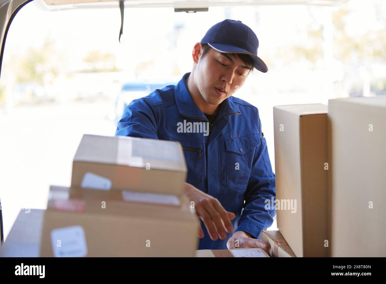 Japanese delivery man checking boxes in the car Stock Photo - Alamy