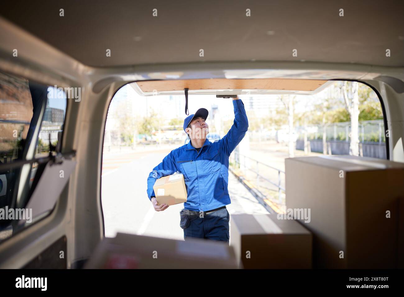 Japanese delivery man checking boxes in the car Stock Photo - Alamy