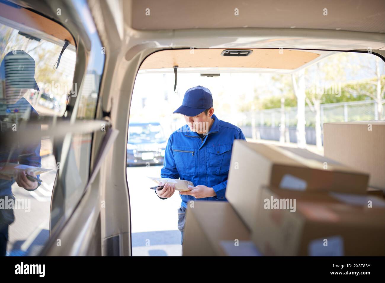 Japanese delivery man checking boxes in the car Stock Photo - Alamy