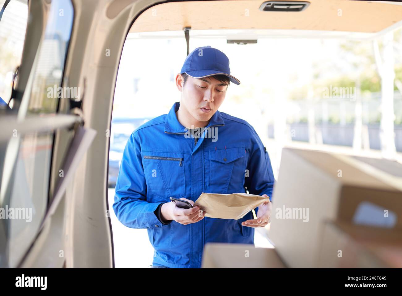 Japanese delivery man checking boxes in the car Stock Photo - Alamy