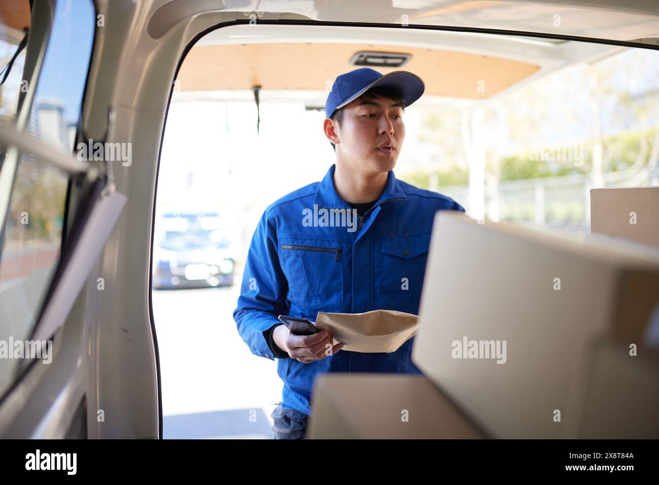 Japanese delivery man checking boxes in the car Stock Photo - Alamy