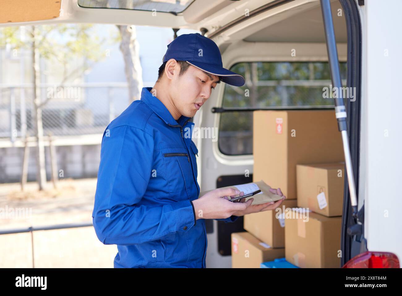 Japanese delivery man checking boxes in the car Stock Photo - Alamy