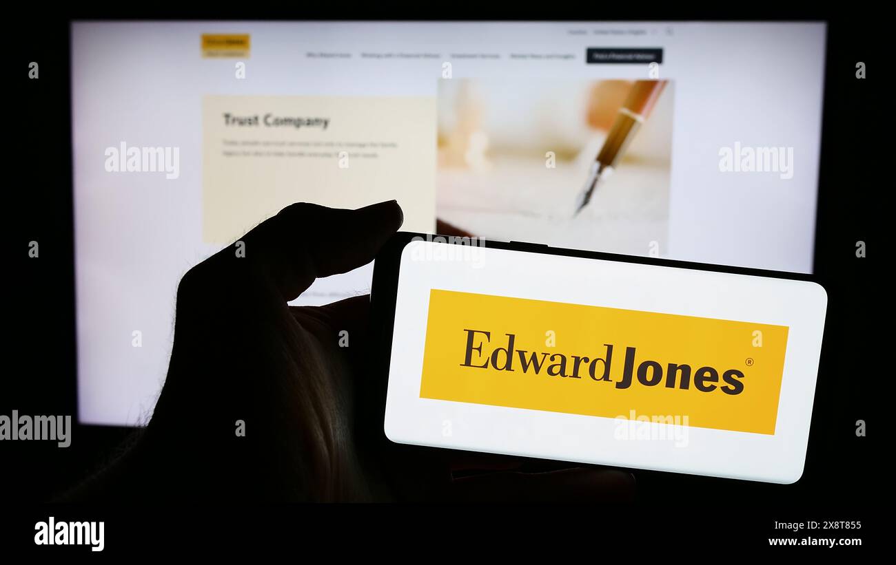 Person holding mobile phone with logo of US financial services company ...