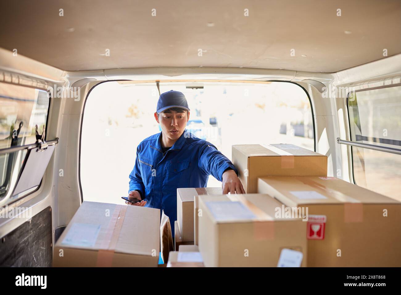 Japanese delivery man checking boxes in the car Stock Photo - Alamy
