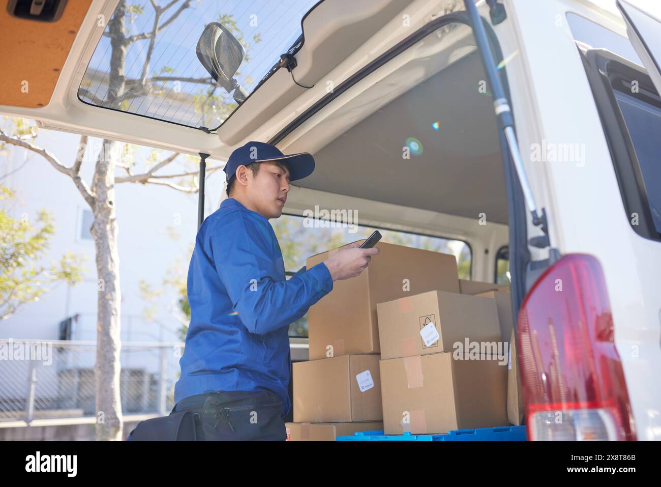Japanese delivery man checking boxes in the car Stock Photo - Alamy