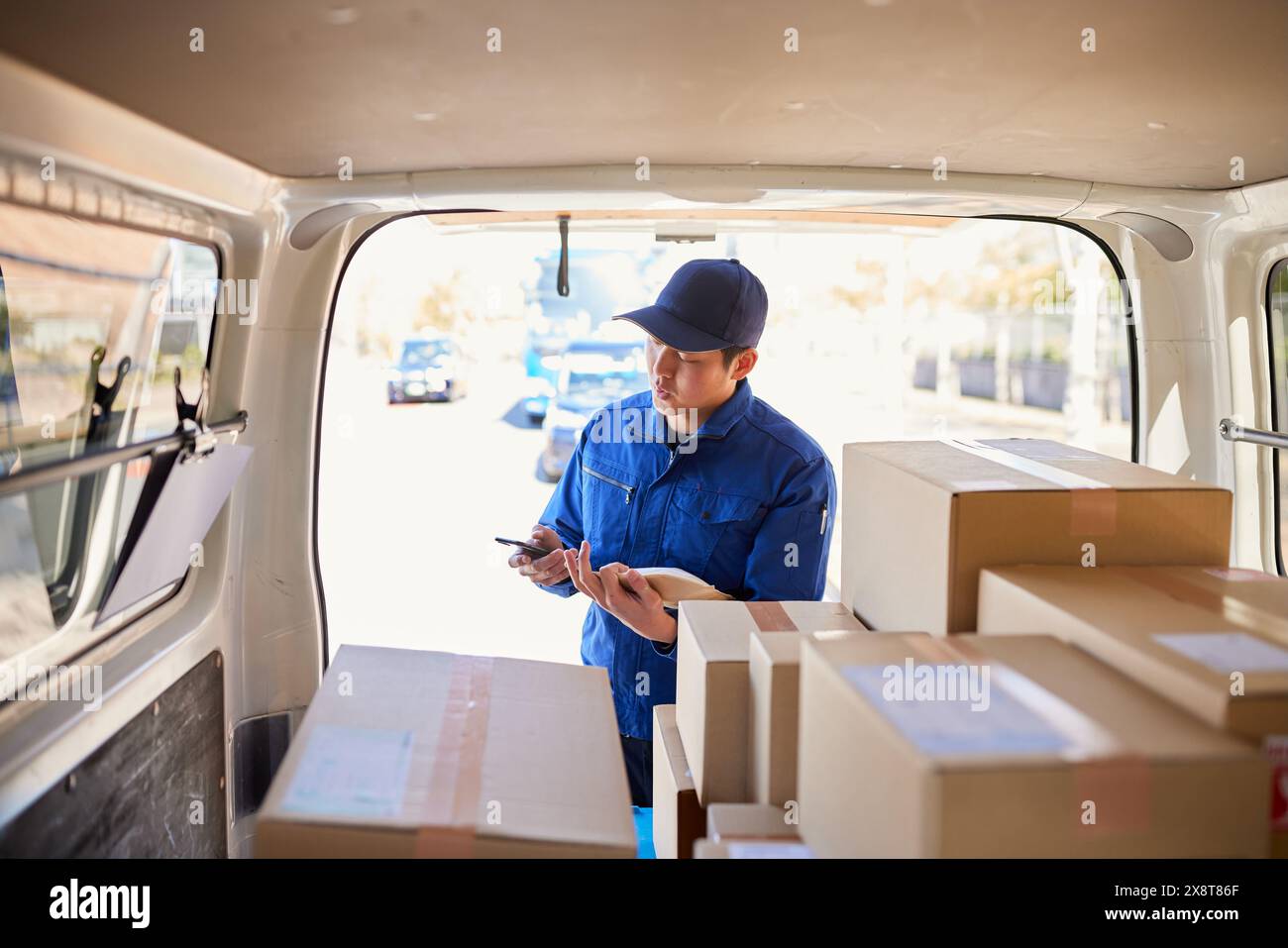 Japanese delivery man checking boxes in the car Stock Photo - Alamy