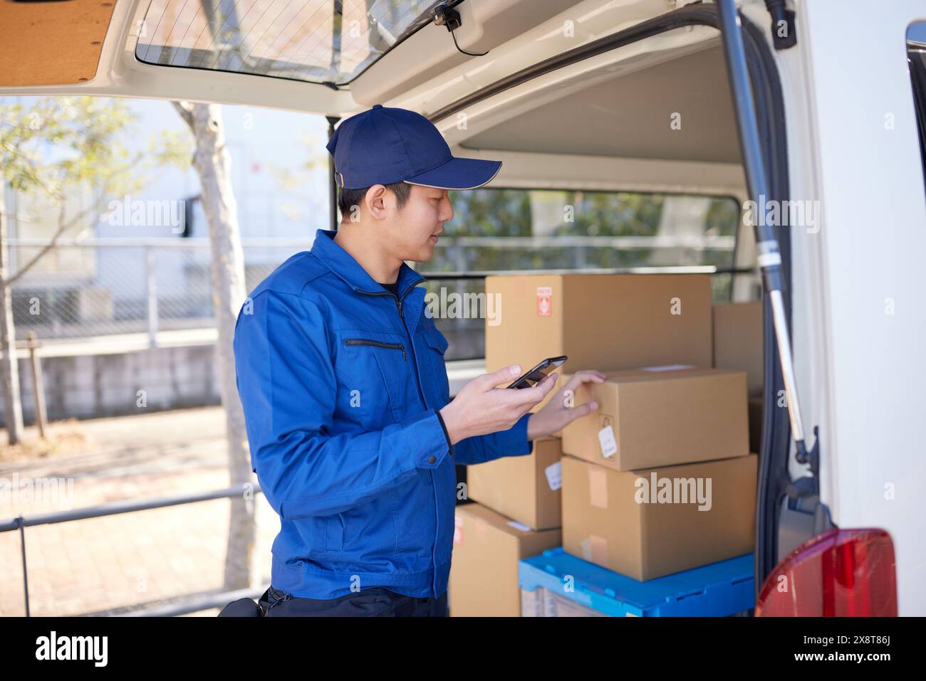 Japanese delivery man checking boxes in the car Stock Photo - Alamy