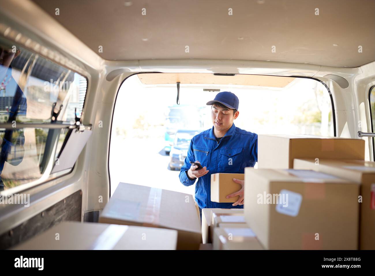 Japanese delivery man checking boxes in the car Stock Photo - Alamy