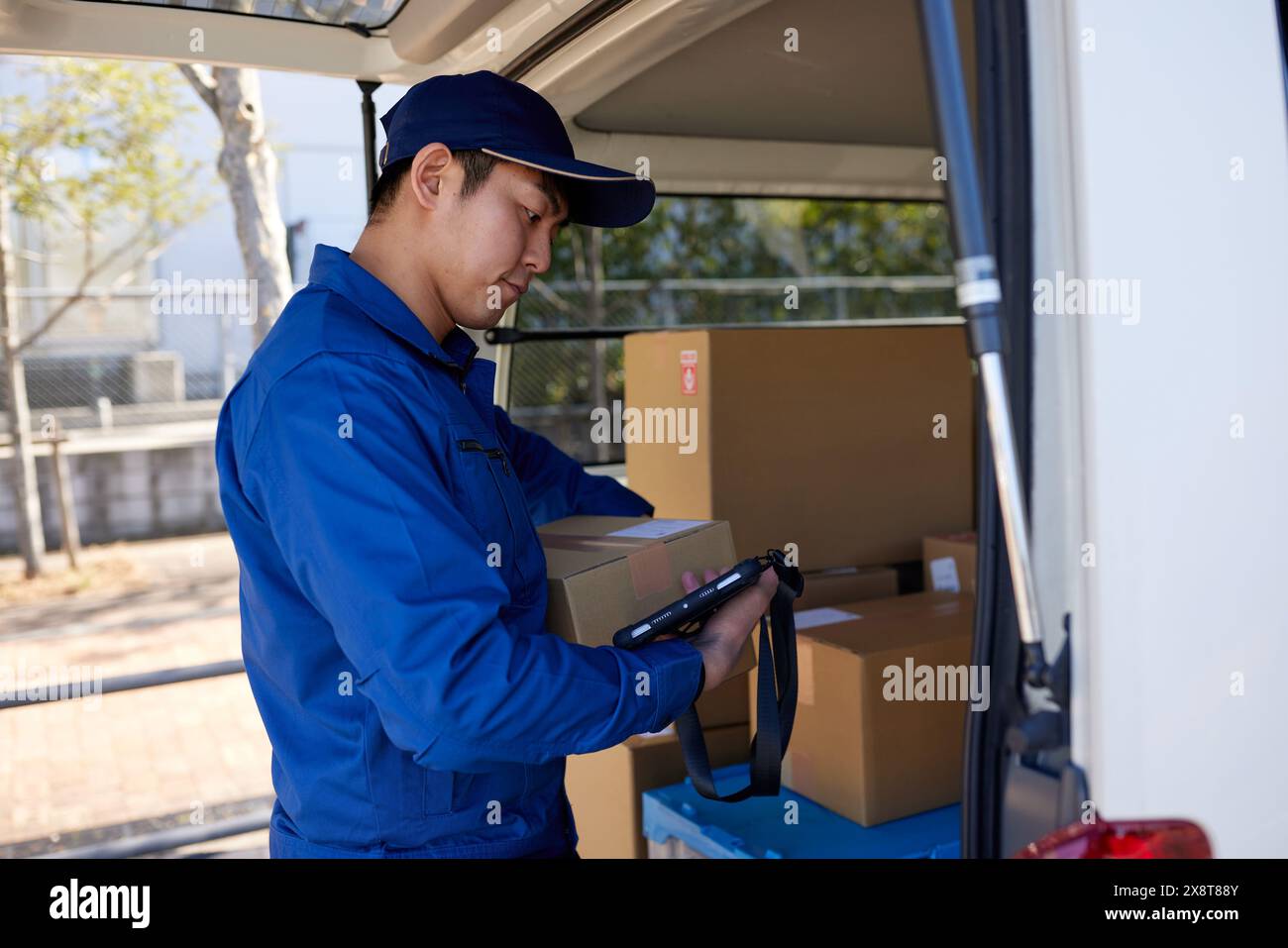 Japanese delivery man checking boxes in the car Stock Photo - Alamy