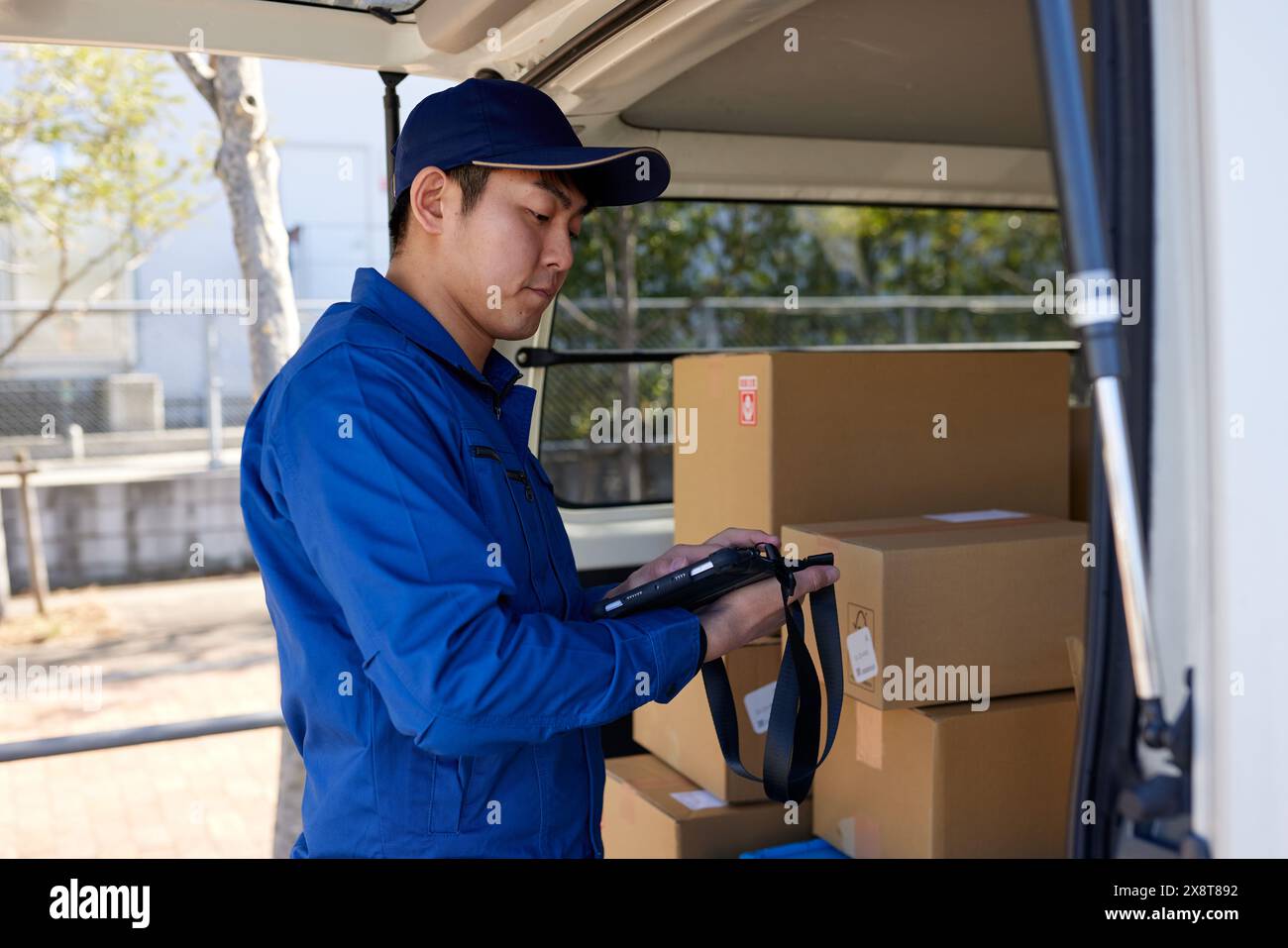 Japanese delivery man checking boxes in the car Stock Photo - Alamy