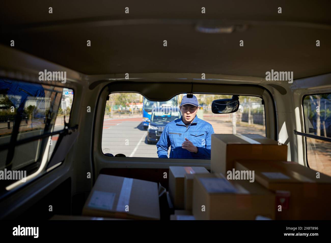 Japanese delivery man checking boxes in the car Stock Photo - Alamy