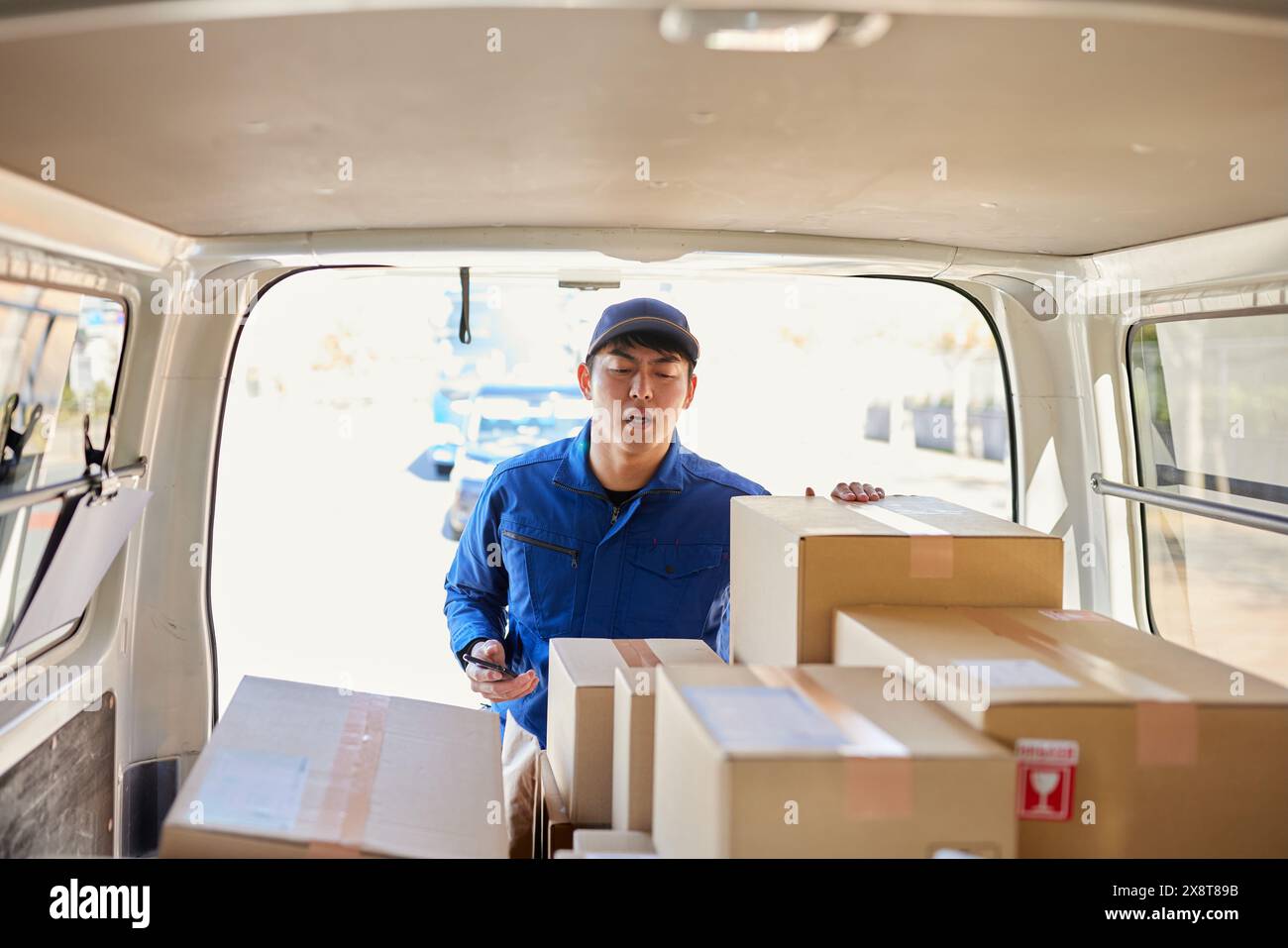 Japanese delivery man checking boxes in the car Stock Photo - Alamy