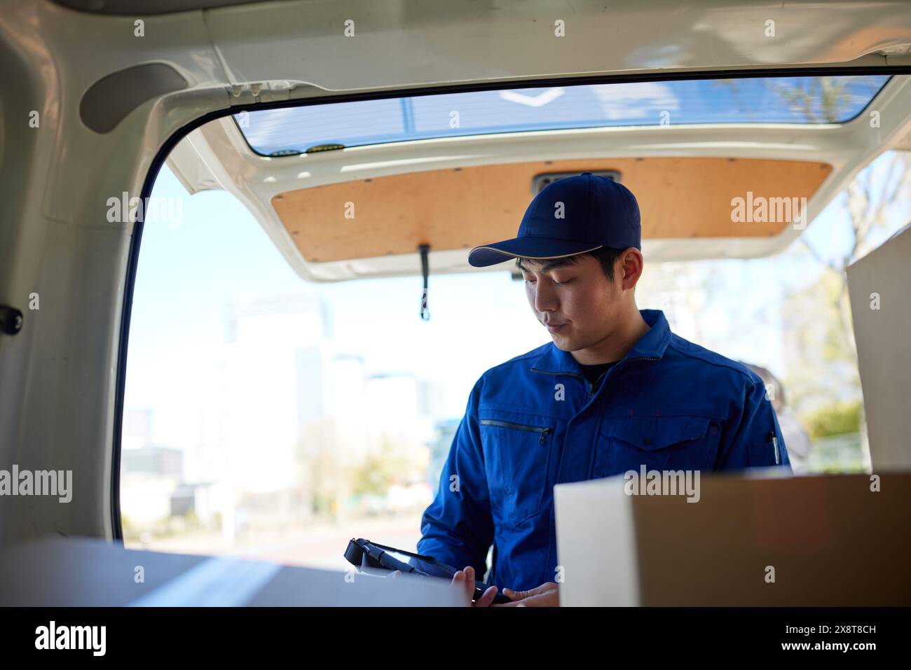 Japanese delivery man checking boxes in the car Stock Photo - Alamy