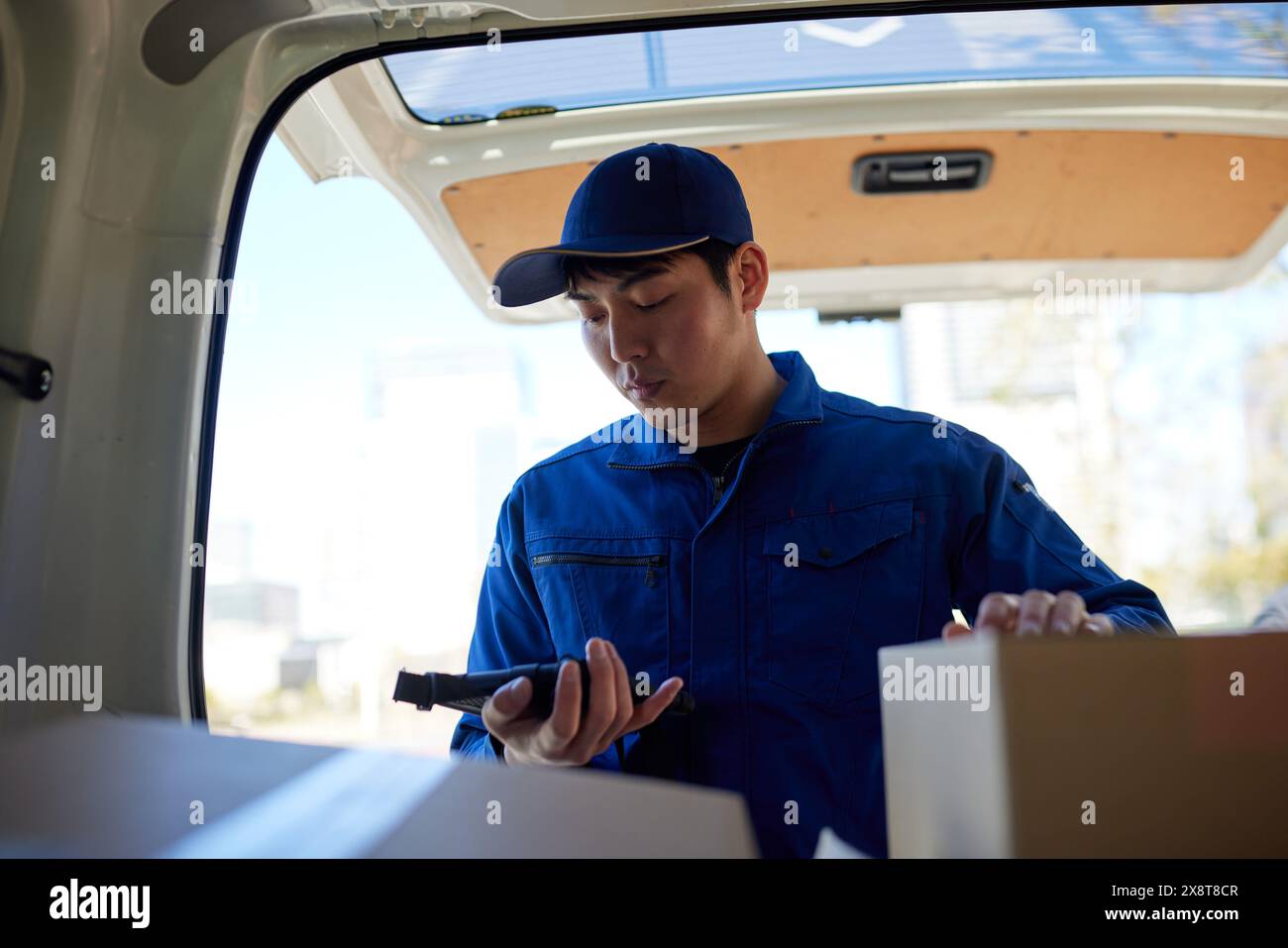 Japanese delivery man checking boxes in the car Stock Photo - Alamy
