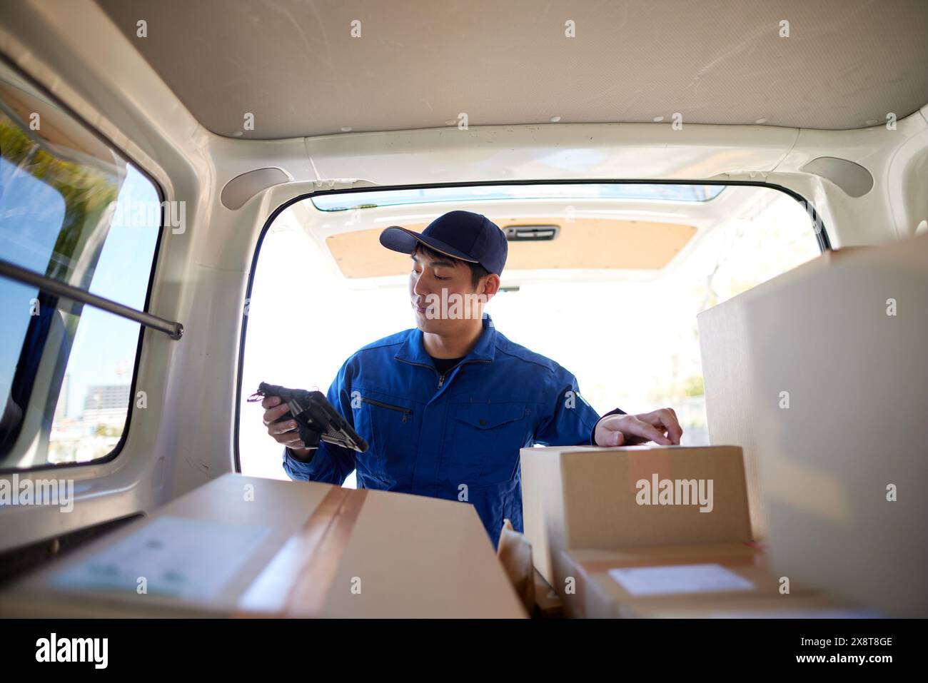 Japanese delivery man checking boxes in the car Stock Photo - Alamy