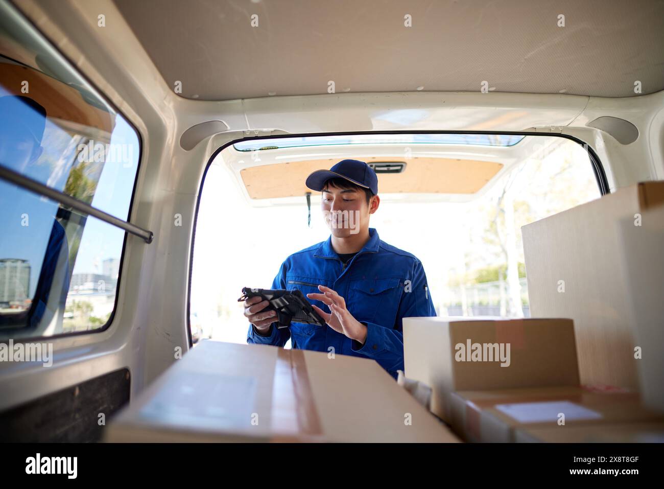 Japanese delivery man checking boxes in the car Stock Photo - Alamy