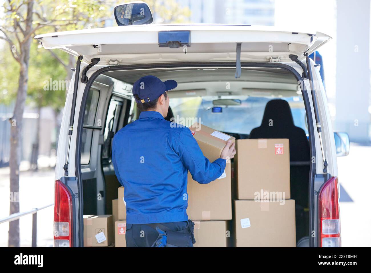 Japanese delivery man checking boxes in the car Stock Photo - Alamy