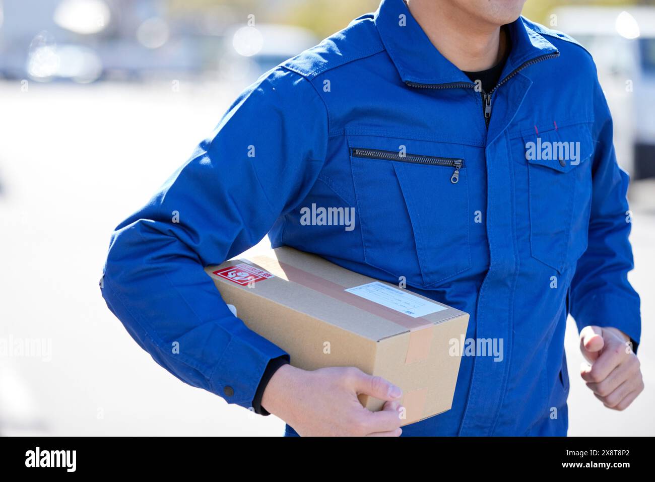 Japanese delivery man carrying a box Stock Photo - Alamy