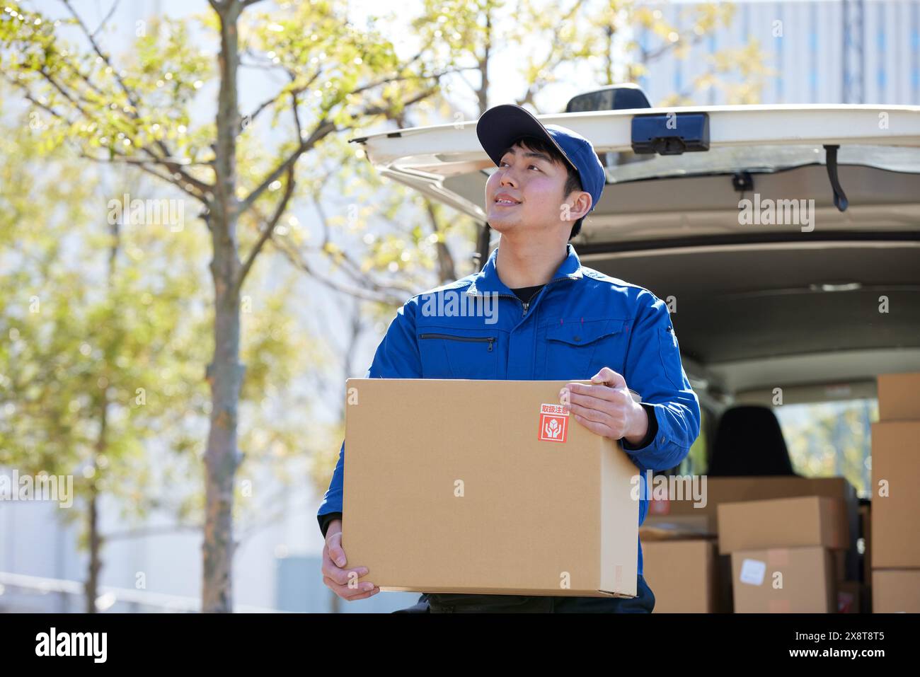 Japanese delivery man holding a box Stock Photo - Alamy