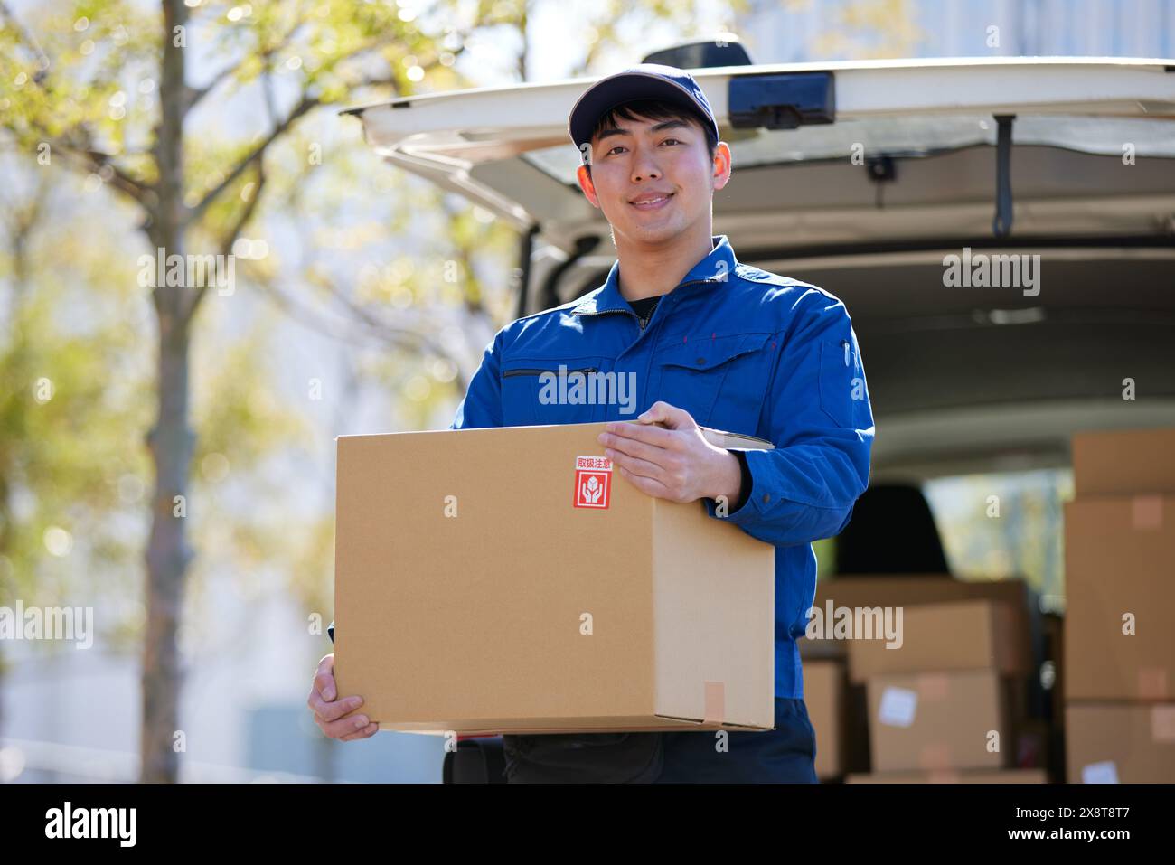Japanese delivery man holding a box Stock Photo - Alamy