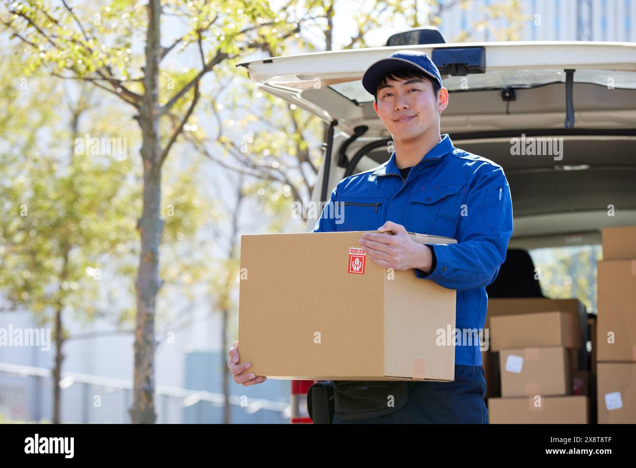 Japanese delivery man holding a box Stock Photo - Alamy