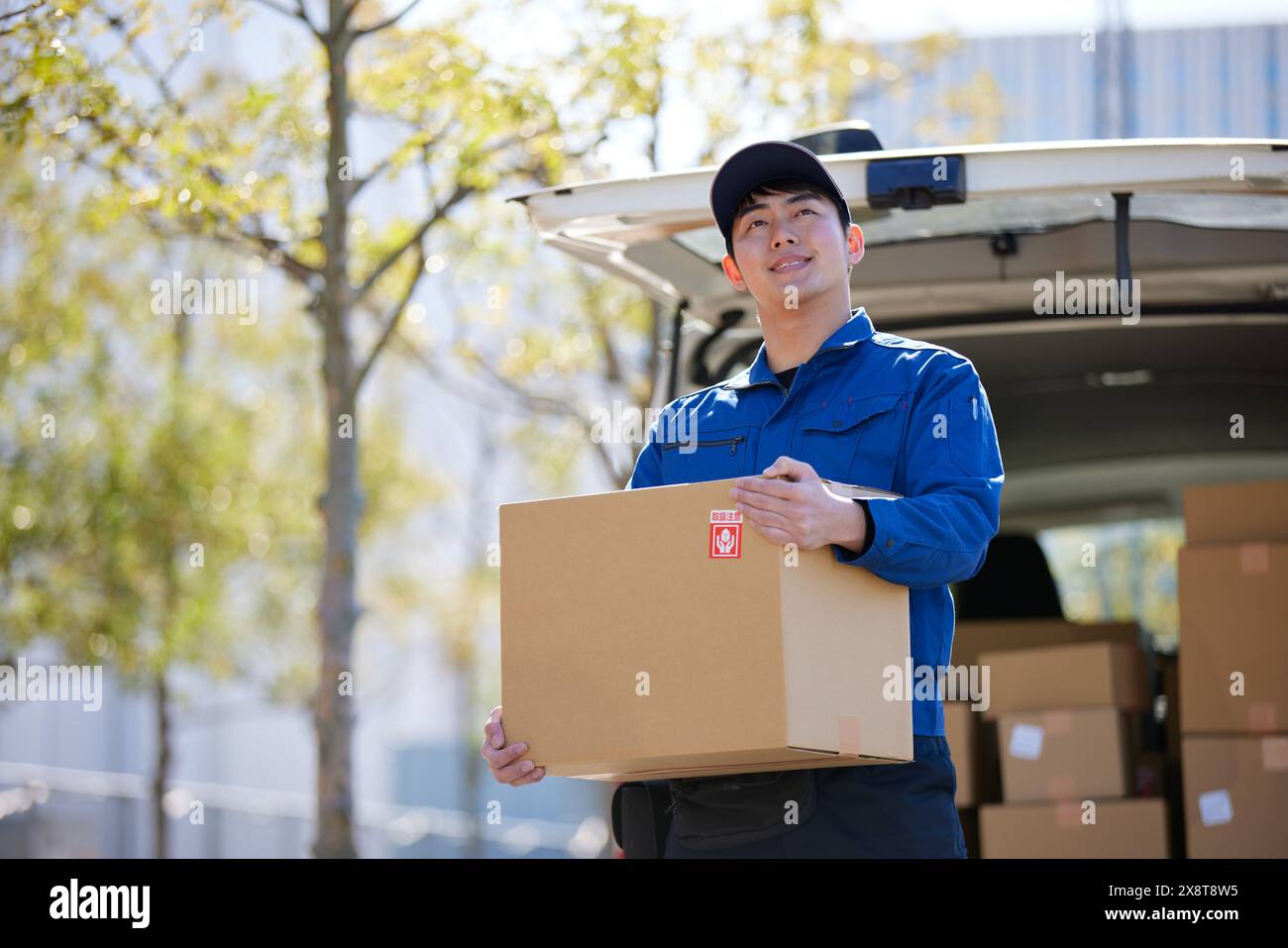Japanese delivery man holding a box Stock Photo - Alamy