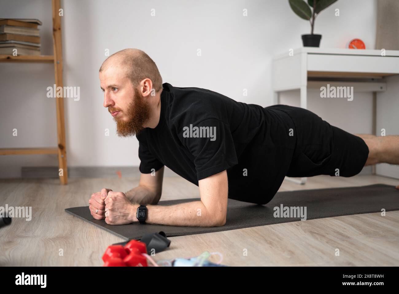 A man is doing plank exercises at home to improve fitness, focusing on ...