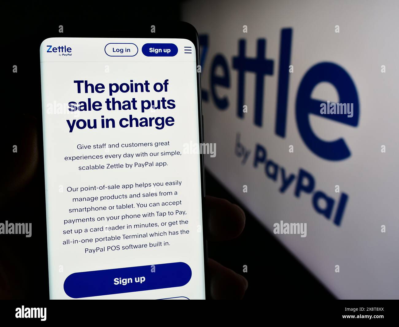 Person holding cellphone with web page of Swedish fintech company ...