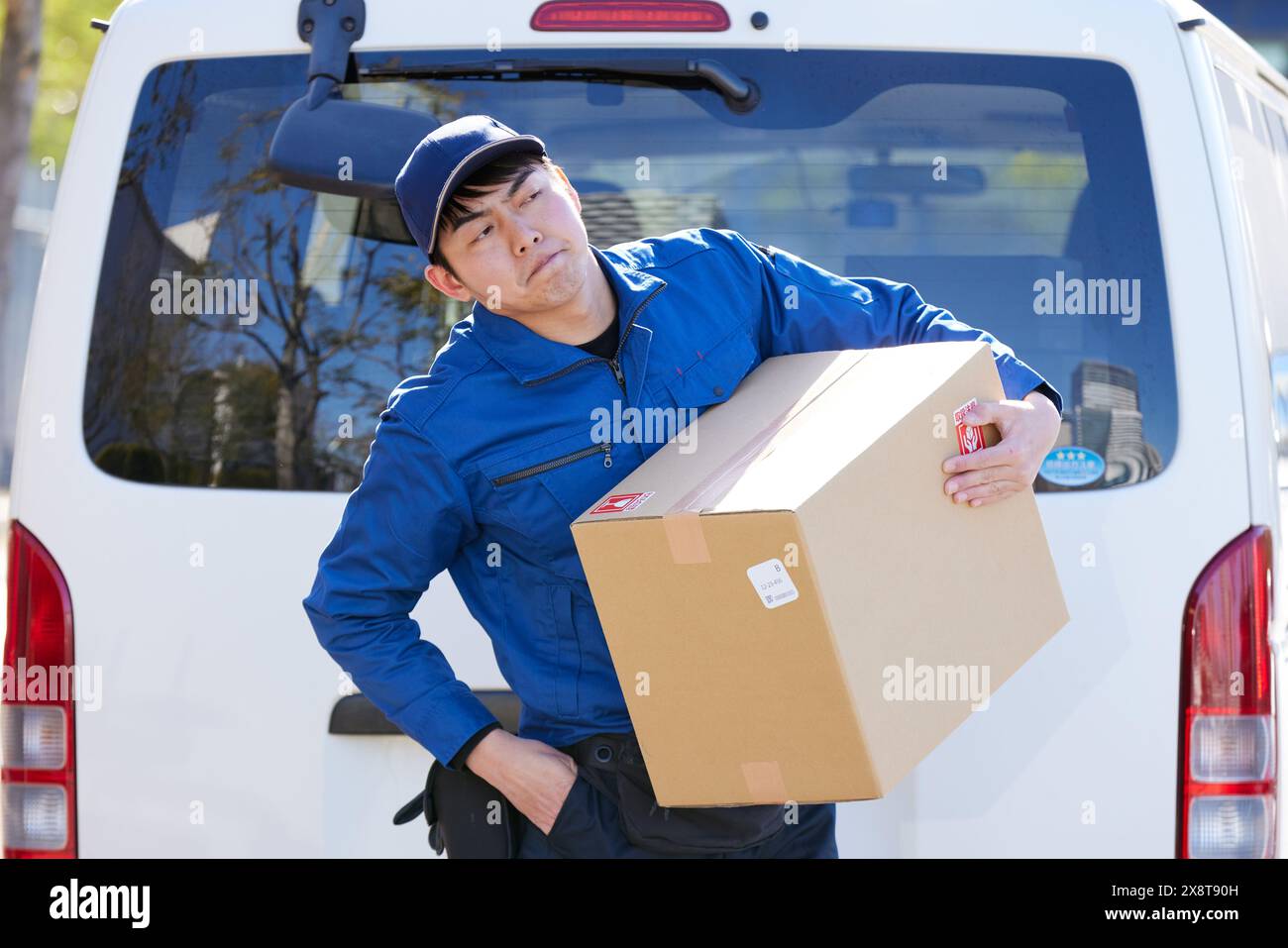 Japanese delivery man carrying a box Stock Photo - Alamy